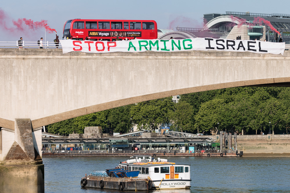 Protesters hang 80-foot banner reading “Stop Arming Israel” from ...